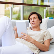 Chilling on the sofa with her tech | Buy Stock Photo on PeopleImages ...