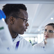 Young african american scientist checking samples with a female ...