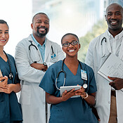 Group of doctors and nurses standing in a line with their arms crossed ...
