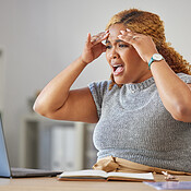 Frustrated, angry, annoyed business woman reading emails on a laptop in ...