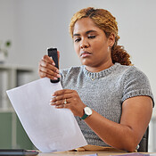 Female office worker stapling paper together in her office at work ...