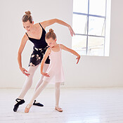 Ballet, elegance and dancing instructor teaching a little ballerina ...