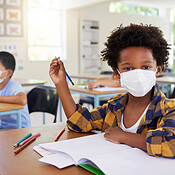 Child or student in class during covid, wearing a mask for hygiene and ...