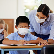 Covid, education and learning with a teacher wearing a mask and helping ...