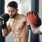 Fitness, training and a man boxing in gym with personal trainer and ...