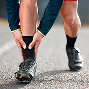 Run injury, feet and sport runner athlete on a outdoor road feeling ...