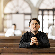Prayer, religious and young man in church with congregation, faithful ...