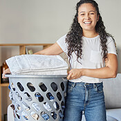 Woman, portrait and laundry basket for cleaning and folding of clothing ...