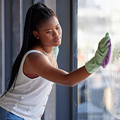 Housework, hygiene and black woman cleaning the window with cloth while ...