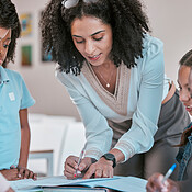 African teacher teaching children, helping students in classroom with ...