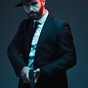 Man, suit or holding gun on dark studio background in secret spy ...