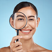 Magnifying glass, face portrait and skincare of woman in studio ...