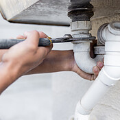 Hands, tool and pipe with a man plumber fixing a water system as a DIY ...