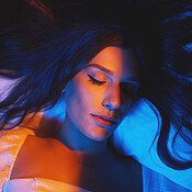 Sleeping, vaporwave lights and woman with eyes closed in bedroom with ...