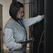 Tablet, server room and engineering with a programmer asian woman at ...