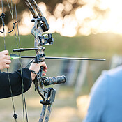 Archery, closeup and target training with an instructor on field for ...