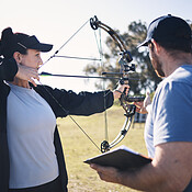 Archery, bow and arrow with woman and coach, aim at target with sports ...