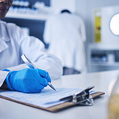 Woman scientist, documents and hands writing vaccine review, planning ...