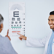 Eye exam, doctor and patient with vision and healthcare, reading chart ...