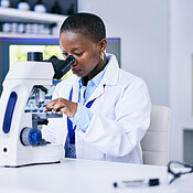 Scientist, black woman and microscope, analysis and science study with ...