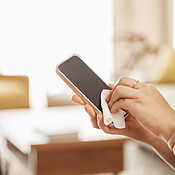 Woman, hands and wipe phone with tissue paper to prevent germs, dirt or ...