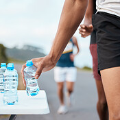 Hand, water and a marathon runner in a fitness competition or race ...
