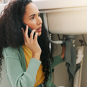 Sink repair, plumbing and woman on a phone call for maintenance ...