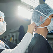 Surgery, hospital and doctors tie mask in operating room for medical ...