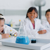 School kids, science and teacher with beaker in class for learning ...