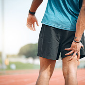 Runner, leg cramp and pain on track in stadium, cardio workout and ...