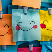 Sticky notes, art and drawing with smiley emoji in notice board for ...