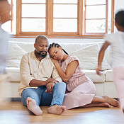 Tired African American couple sitting on the lounge floor looking tired ...