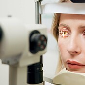 Woman, optometry and slit lamp for vision, test and care in wellness ...