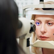Woman, optometry and slit lamp for check, vision and care in wellness ...