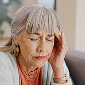 Senior woman, thinking and stress in nursing home, hand and memory of past, retirement and ...