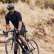 Athletic young man cycling on a mountain road. Sporty fit male cyclist ...