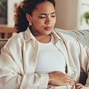 Stomach ache, pain and sick woman in home with diarrhea, period cramps ...