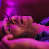 Drugs, overdose and man on couch in dark with needle, health risk and ...