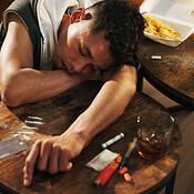 Drugs, overdose and man with face on table, health risk and narcotic ...