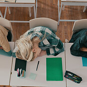 Tired, sleeping and group of students on desk in classroom at school ...