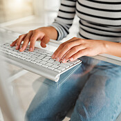 Businessperson typing on a keyboard working on a desktop computer while ...
