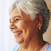 Smile, thinking and senior woman in home for view, reflection or nostalgia by window in living ...