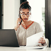 Phone call, paperwork and woman with laptop in home with communication ...