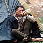 Man, poverty and outdoor with alcohol, drink and tent with addiction ...