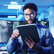 CCTV, security and tablet with man in office at night for monitoring ...