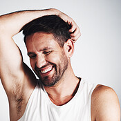 Happy, man and smell of underarm, studio and sniffing of deodorant for ...