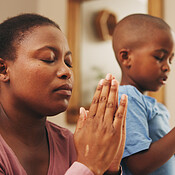 Praying, religion and black mother with child in home for worship ...