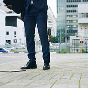 Feet, business and person with shoes in city for travel, drop documents ...