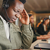 Call center, customer service and man in office with headache from ...