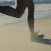 Running, fitness and legs of a woman at the beach, marathon training ...